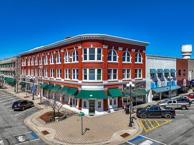 The wide streets and red-brick corner building, along with neighboring stores, create an atmosphere where every visit feels like coming home to family.