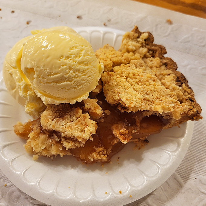 Apple pie with crumble topping and melting ice cream—proof that happiness isn't complicated, it just needs the right crust-to-filling ratio.