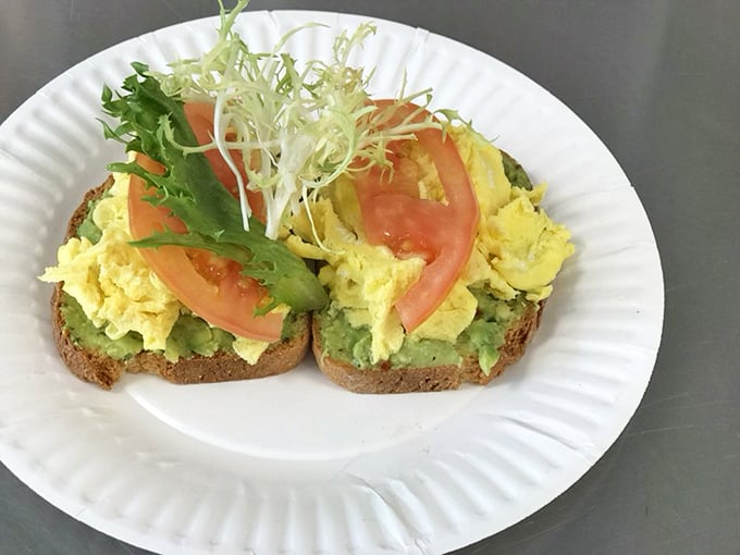Avocado toast that actually justifies the hype—creamy green goodness topped with perfectly scrambled eggs and fresh tomato.