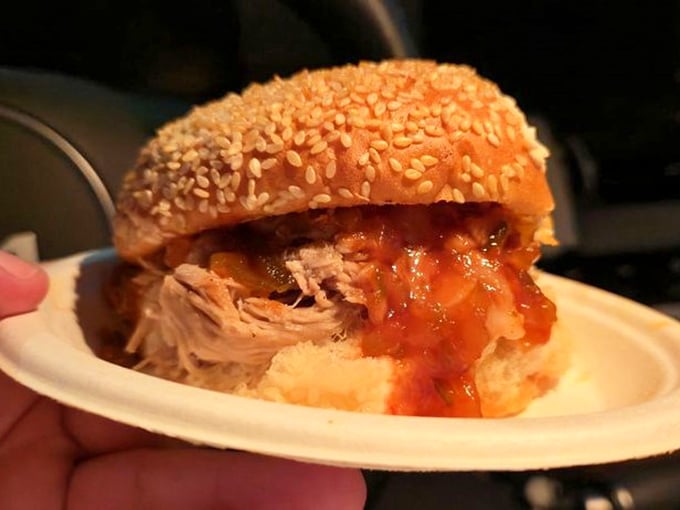 BBQ sandwich perfection—tender pulled meat meets tangy sauce on a sesame throne. The kind of sandwich that demands a stack of napkins and zero shame.