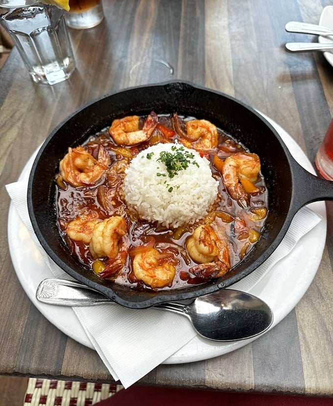 The New Orleans BBQ shrimp arrives like a delicious hurricane in a skillet—rich sauce, plump shrimp, and that island of rice in the center for soaking up flavor.