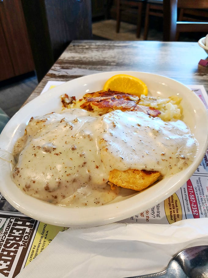 Biscuits swimming in gravy with a side of crispy bacon – the kind of plate that makes you want to hug the cook.