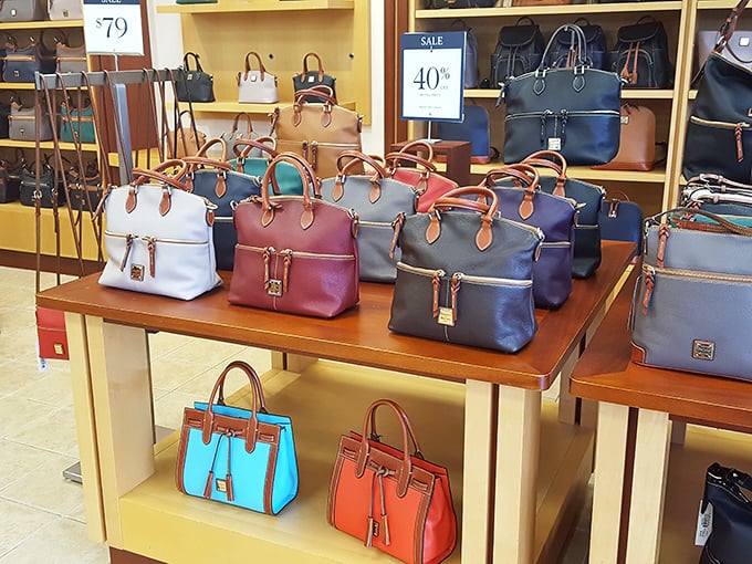 A rainbow of designer handbags stands at attention, each one silently whispering, "I'm 60% off and still more stylish than anything in your closet."
