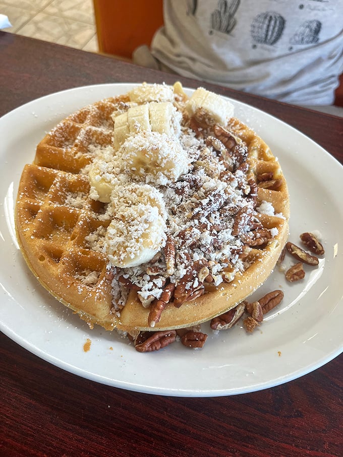 This isn't just a waffle—it's an edible pedestal showcasing pecans, powdered sugar, and butter melting into those perfect golden squares.