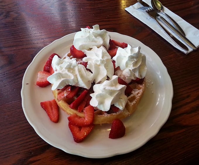 A Belgian waffle crowned with fresh strawberries and whipped cream – breakfast masquerading as dessert, and nobody's complaining.