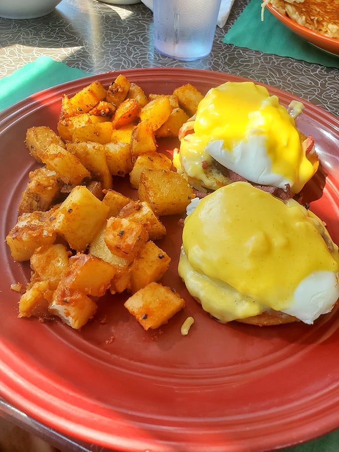 Eggs Benedict executed with textbook precision. The hollandaise sauce cascades like a yellow waterfall of breakfast perfection, while those home fries stand ready for duty.
