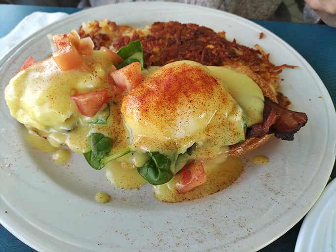 Eggs Benedict here isn't just breakfast—it's performance art with hollandaise as the headliner, paprika as the spotlight, and spinach stealing scenes throughout.