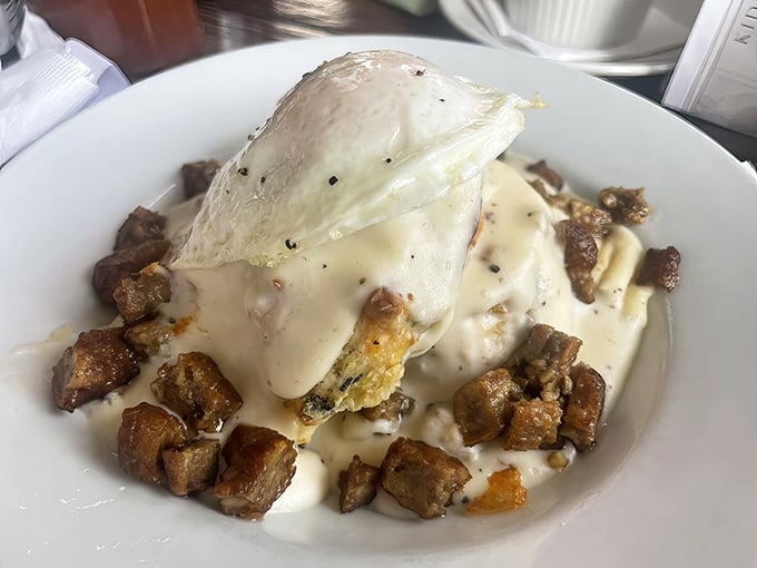 Comfort food royalty: fluffy biscuits drowning in rich gravy alongside perfectly seasoned breakfast potatoes.