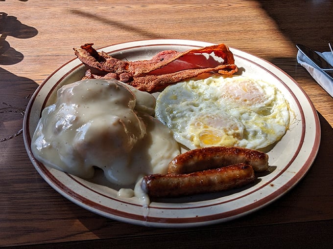 Breakfast nirvana achieved: golden-brown biscuits swimming in savory gravy with eggs and meat playing the perfect supporting roles.