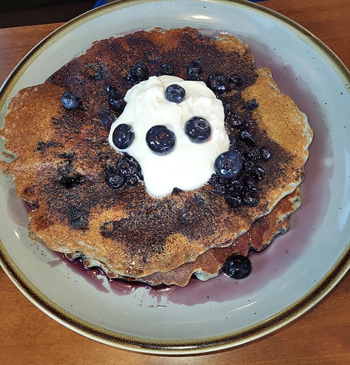 These blueberry pancakes aren't just breakfast, they're edible art—a canvas of golden batter dotted with bursts of purple-blue joy.