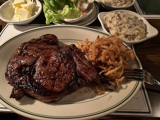 This isn't just a steak – it's a masterpiece with a bone handle. Those crispy onion straws are the supporting actors that deserve their own Oscar.
