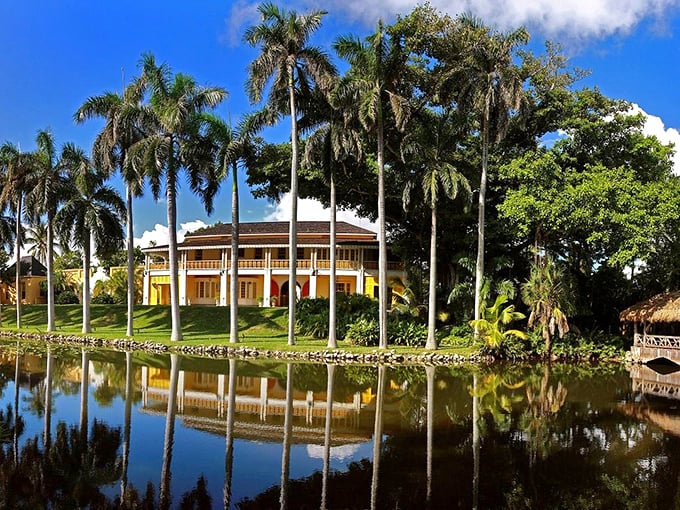 The main house reflects in the lily pond like a tropical Versailles, where royal palms stand at attention guarding this waterfront treasure.