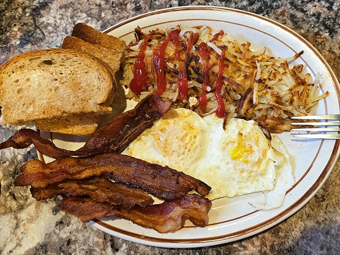 Breakfast perfection on a plate—crispy hash browns, eggs with sunset-yellow yolks, and bacon that makes you question why you'd eat anything else.