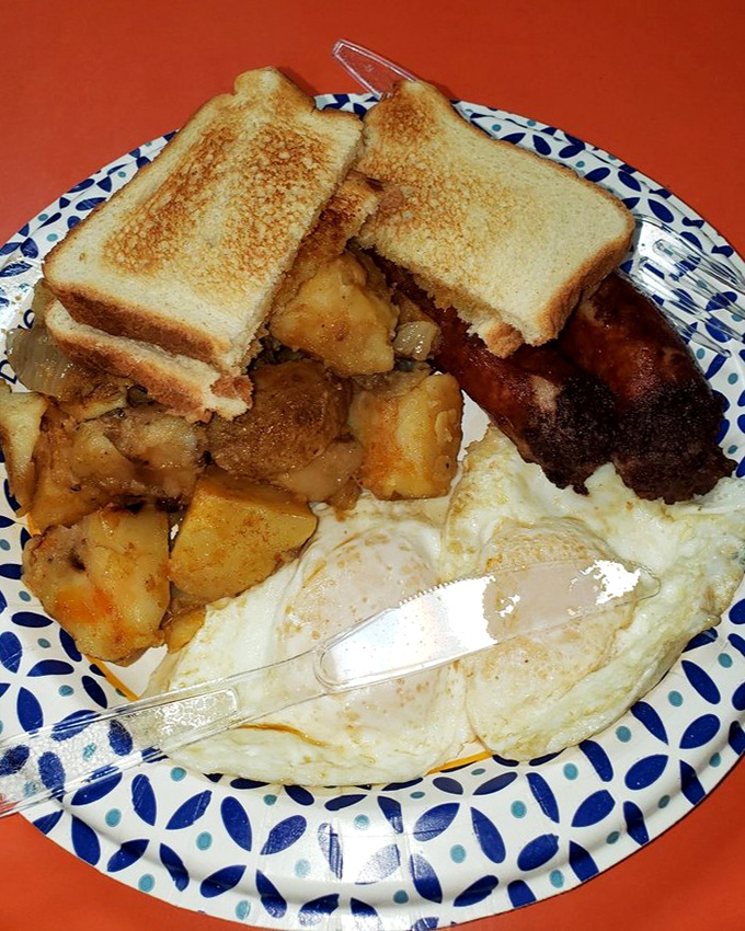 Breakfast perfection on a blue-patterned plate – golden home fries, perfectly cooked eggs, and toast ready to sop up every last bit of yolk.
