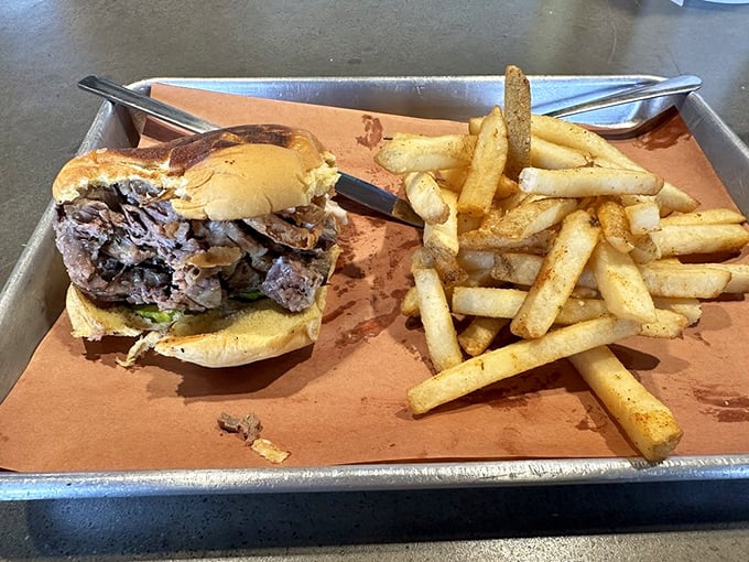 Behold the brisket sandwich—where smoke-kissed beef finds its soulmate in a pillowy bun, while fries stand by as loyal companions. 
