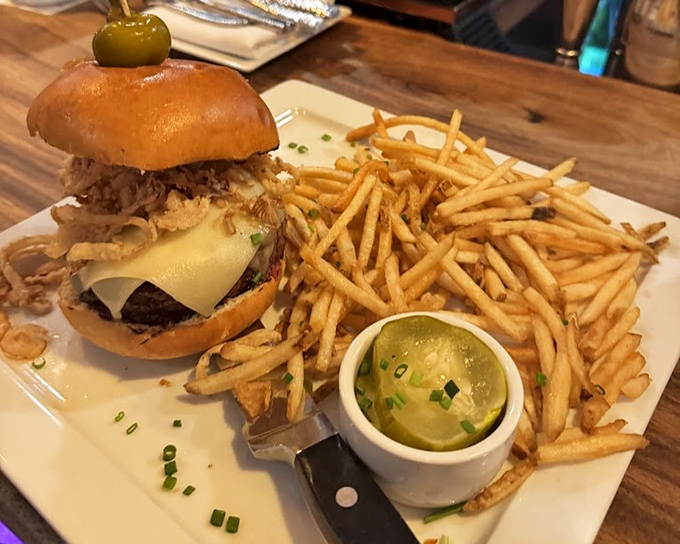 This isn't just a burger—it's architecture. Towering with toppings and flanked by golden shoestring fries that demand to be devoured.