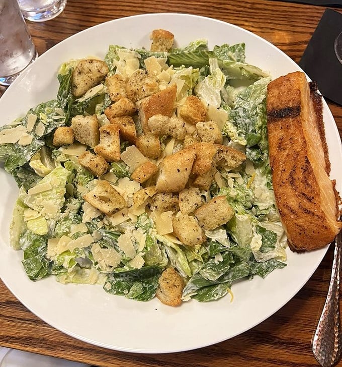 This Caesar salad isn't just playing a supporting role – it's stealing scenes with crisp romaine, generous parmesan, and garlic bread worthy of applause.
