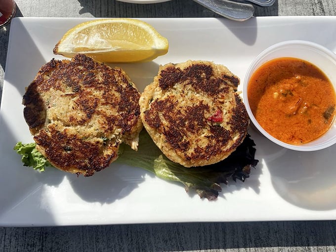 These crab cakes aren't just golden brown—they're the color of culinary achievement. That sauce on the side? Consider it a flavor lifejacket. 