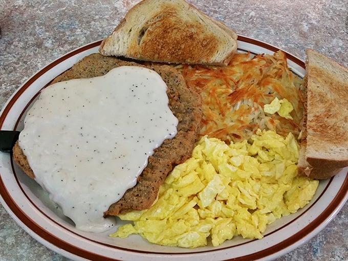 Country gravy blankets this chicken fried steak like a comforting hug. Scrambled eggs and hash browns complete this breakfast trifecta.