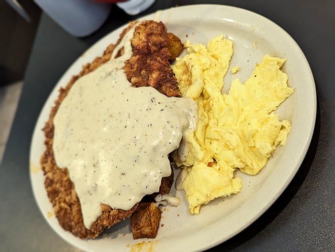 Chicken fried steak with gravy cascading over the edges – Texas on a plate, with eggs playing a sunny supporting role.