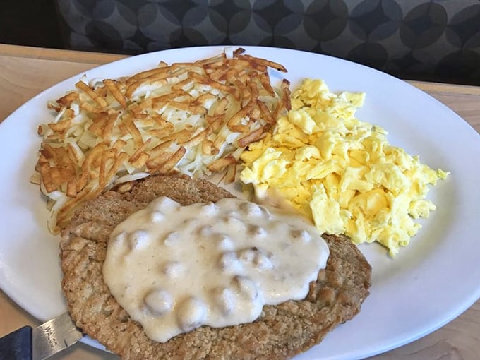 Country-fried steak smothered in gravy alongside golden hash browns and fluffy eggs—the breakfast equivalent of winning the comfort food lottery.