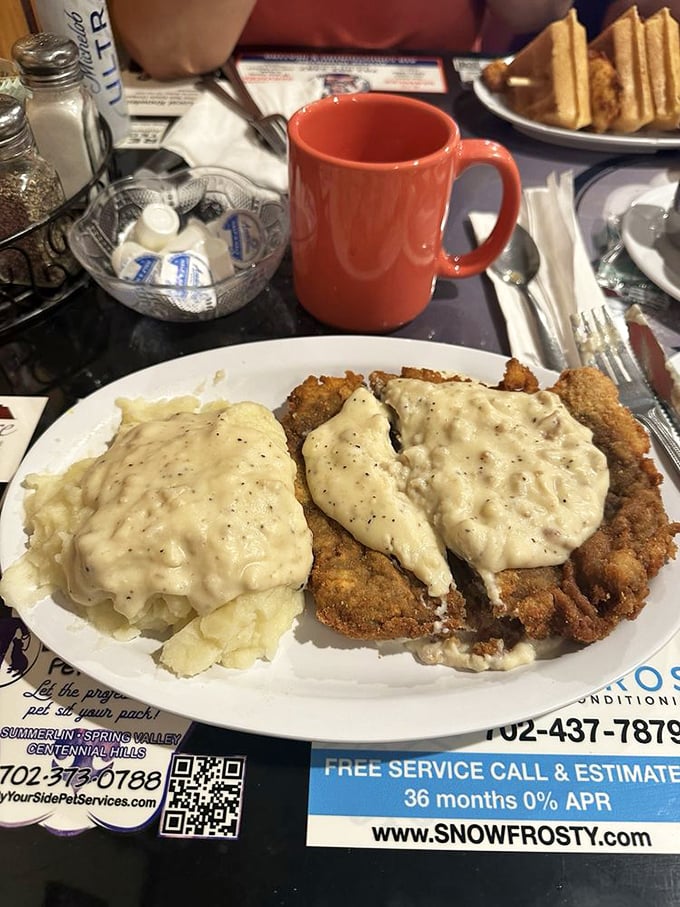 Chicken fried steak smothered in peppery country gravy alongside fluffy mashed potatoes—comfort food that hugs you from the inside out.