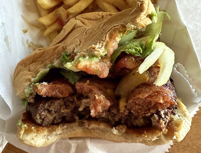 Cut into this burger and witness the perfect cross-section—charred exterior, juicy interior, and toppings in harmonious balance.