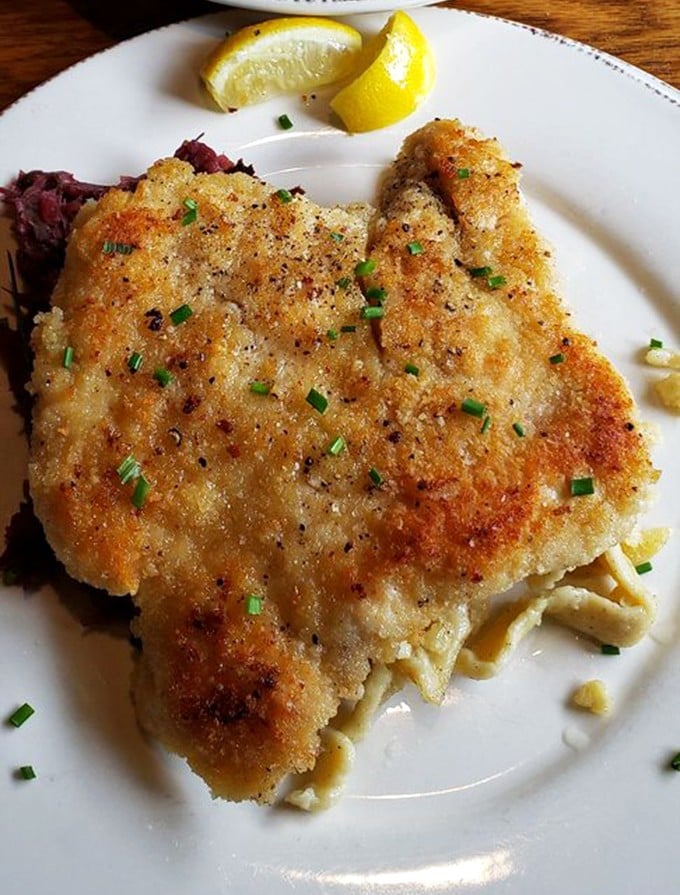 The star of the show—chicken schnitzel with its golden-brown crust that shatters with each bite. That lemon wedge isn't just garnish; it's essential equipment.