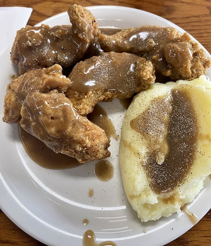 Fried chicken and mashed potatoes swimming in gravy—the kind of plate that makes you want to hug the cook and take a nap simultaneously.