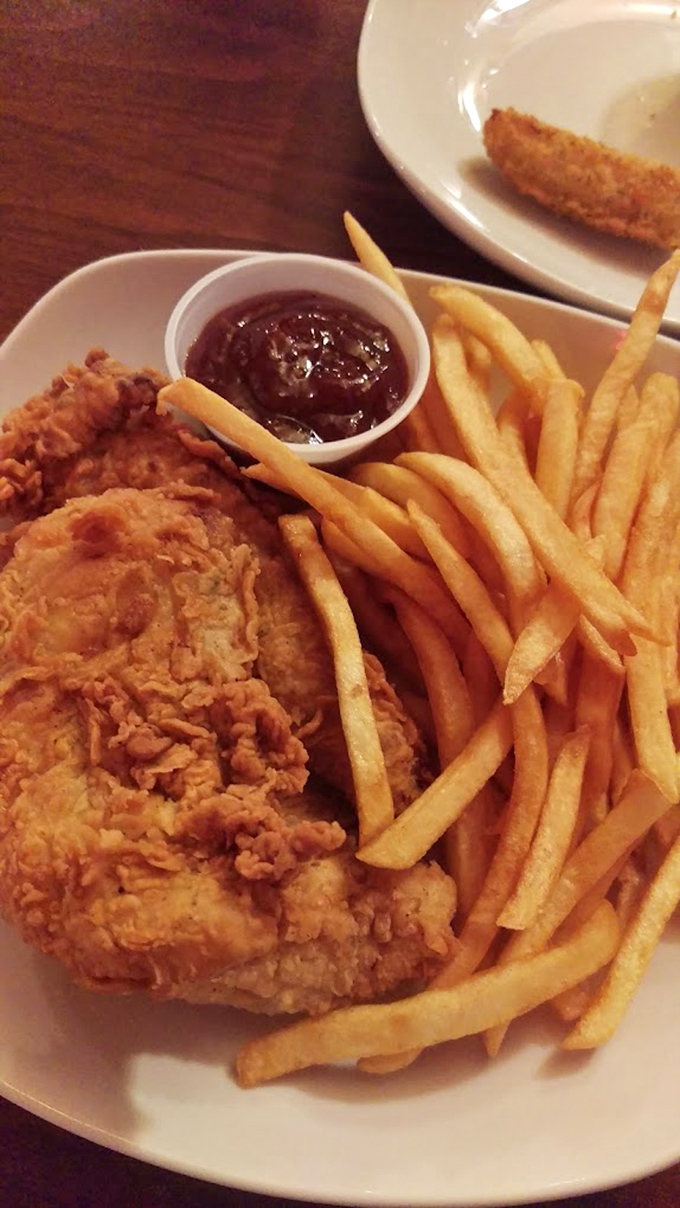 Chicken tenders that actually deserve the name—crispy armor protecting juicy meat within. The kind that makes adults forget they ordered "just to see what the kids eat."