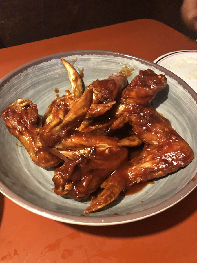 These wings aren't just cooked; they're lacquered with sauce so glossy you could check your reflection before diving in.