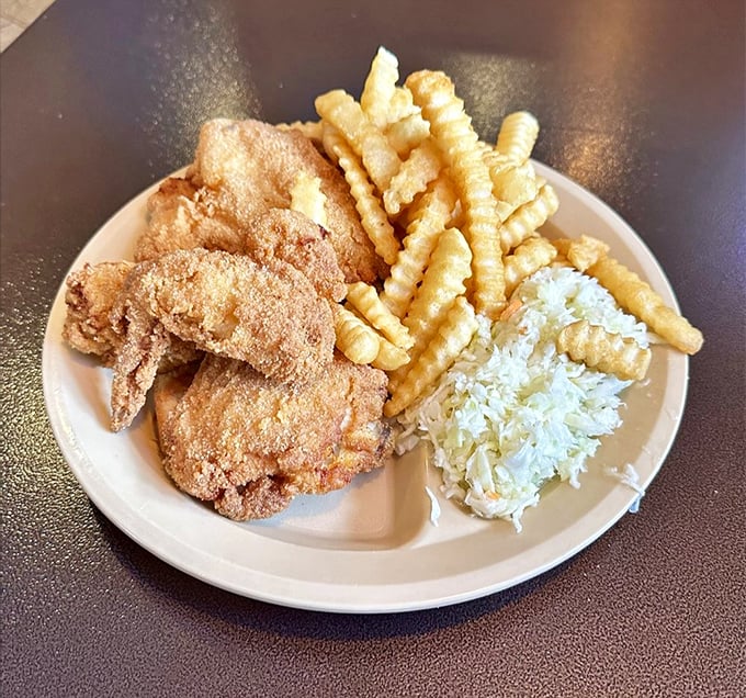 The holy trinity of comfort food: perfectly fried chicken, crispy crinkle-cut fries, and coleslaw that actually deserves a place on your plate.