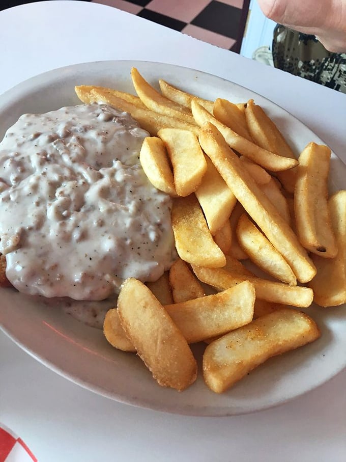 Country gravy cascading over golden fries like a comfort food waterfall. This plate doesn't just feed your hunger—it hugs your soul.