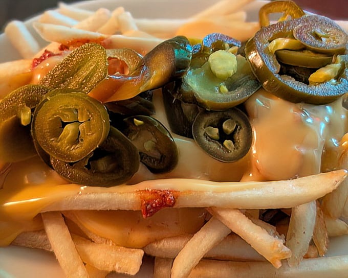 Jalapeños dancing atop a bed of crispy fries smothered in molten cheese – proof that sometimes the side dish steals the spotlight.