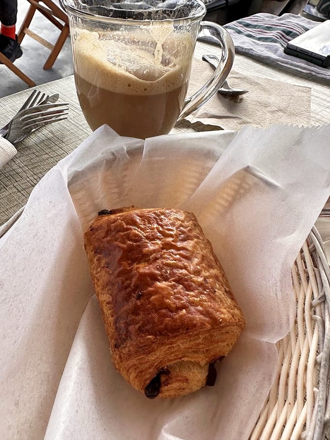 A chocolate croissant and café au lait—the breakfast combo that makes Monday mornings bearable. That golden exterior promises buttery layers within.