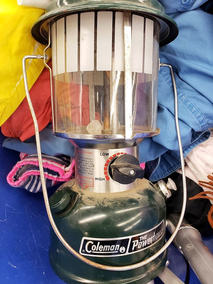 Vintage Coleman lantern nestled among textiles—perfect for your next camping trip or creating that rustic ambiance on your patio.