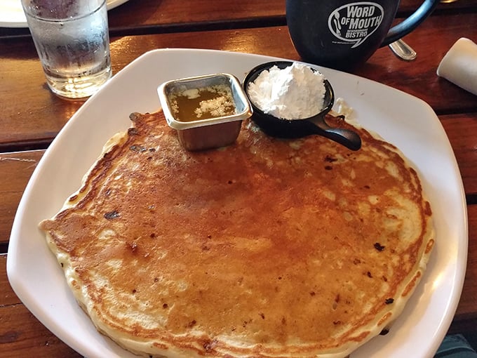 Pancakes so perfectly golden they belong in Fort Knox. The tiny cup of butter melting atop is the crown jewel.