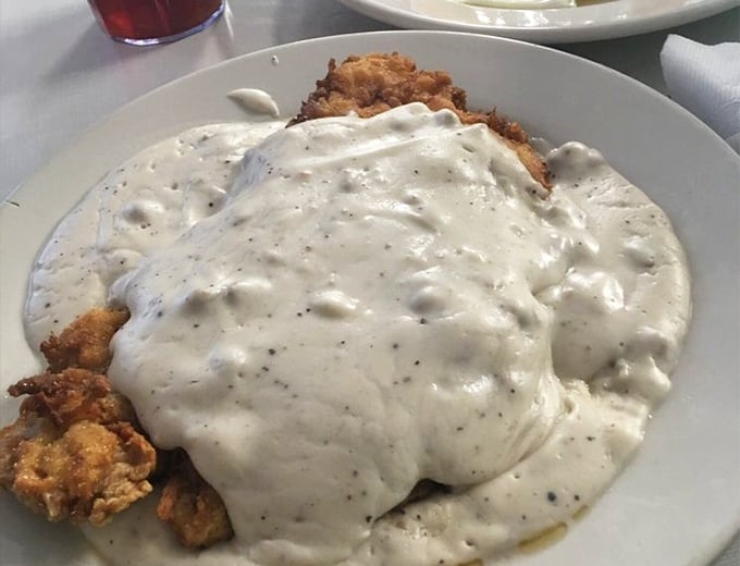Country fried steak swimming in creamy pepper gravy – the kind of dish that makes you want to hug the cook and then take a very satisfied nap.