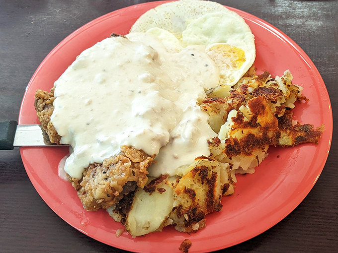 Country fried steak swimming in creamy gravy—the kind of breakfast that makes you understand why lumberjacks could fell trees all day without energy drinks.