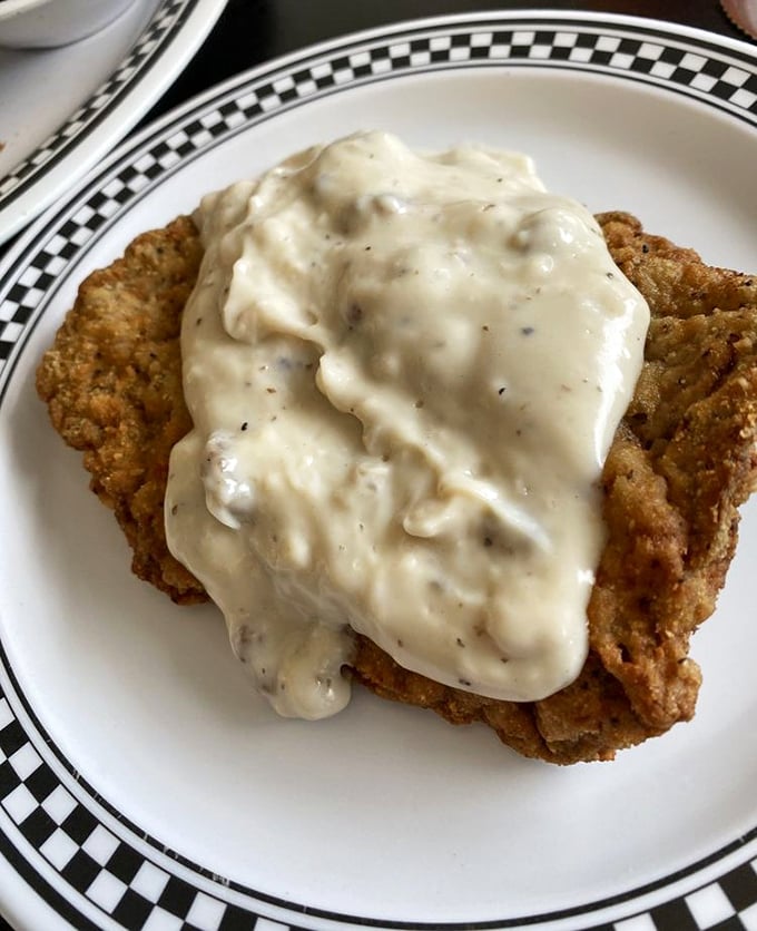 Country fried steak smothered in pepper-speckled gravy—Southern comfort that doesn't need a therapist's couch, just a hungry appetite and appreciation for tradition.