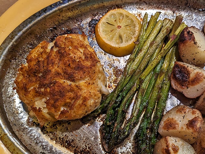 This isn't just a crab cake—it's Maryland's soul on a plate. Golden-brown perfection with asparagus standing at attention alongside.