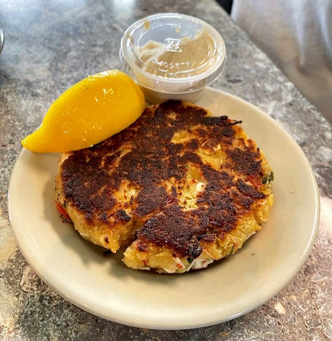 Seafood alchemy at work. This golden-brown crab cake showcases the kitchen's respect for fresh ingredients—minimal filler, maximum flavor.