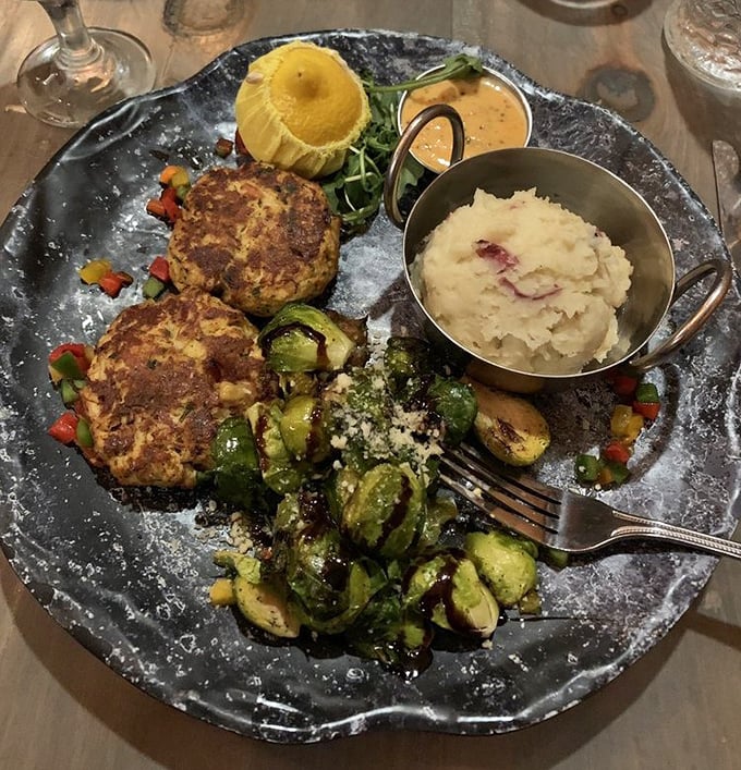 The legendary crab cakes in their natural habitat—golden-brown perfection with minimal filler and maximum flavor. This is what seafood dreams are made of.