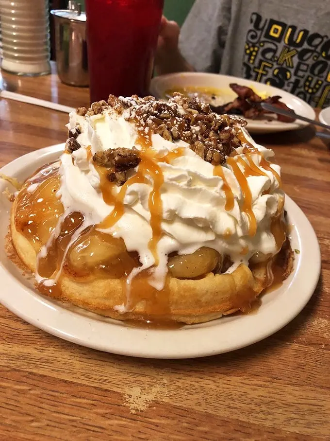 This isn't just a waffle—it's an edible pedestal showcasing caramel, whipped cream, and nuts in perfect harmony.