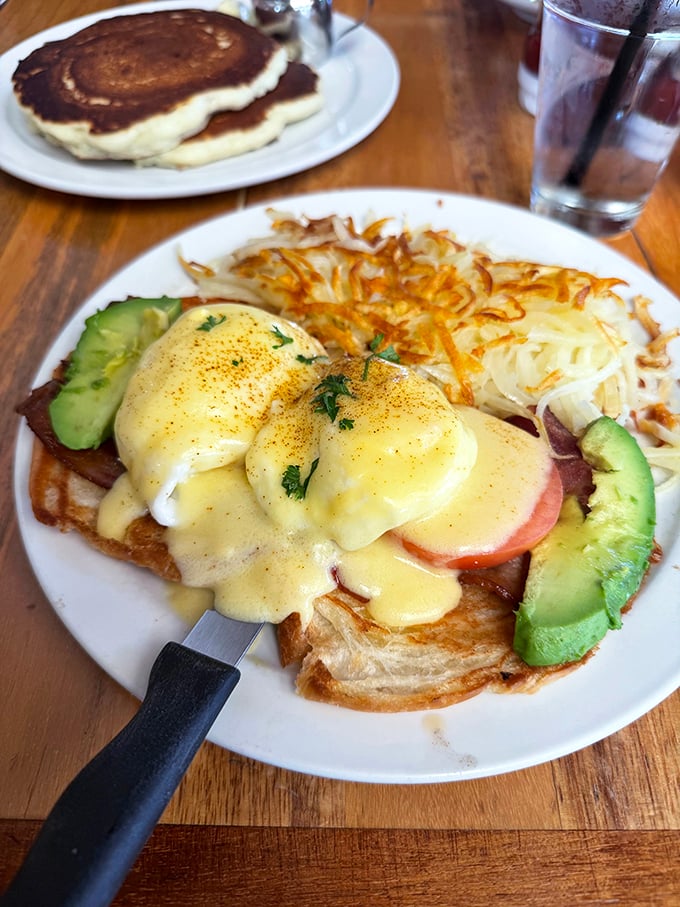 Hollandaise sauce cascading over perfectly poached eggs like a sunrise over the Nevada desert, with avocado adding a California twist.