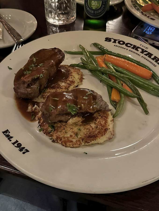 Elk medallions resting on potato pancakes—proof that sometimes the best culinary experiences come from ingredients that once had antlers.