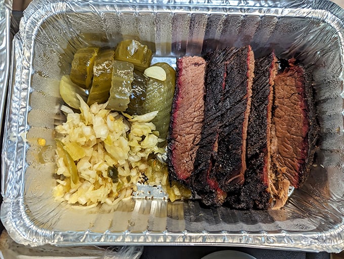Behold the brisket trifecta – each slice sporting that coveted pink smoke ring like a badge of barbecue honor.