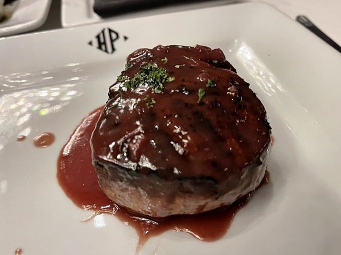 This filet mignon doesn't just sit on the plate – it commands attention with its glistening sauce and perfect doneness that whispers, "You've made an excellent decision."