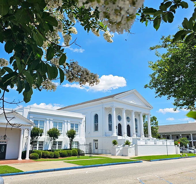 Framed by flowering branches, this stately white church stands as Eufaula's architectural crown jewel, its columns reaching skyward like prayers.