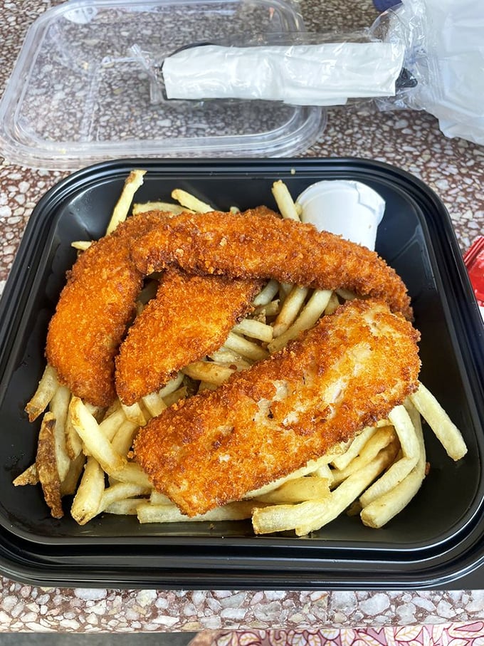 Golden-fried fish sitting atop a mountain of fries—this is comfort food that actually comforts.
